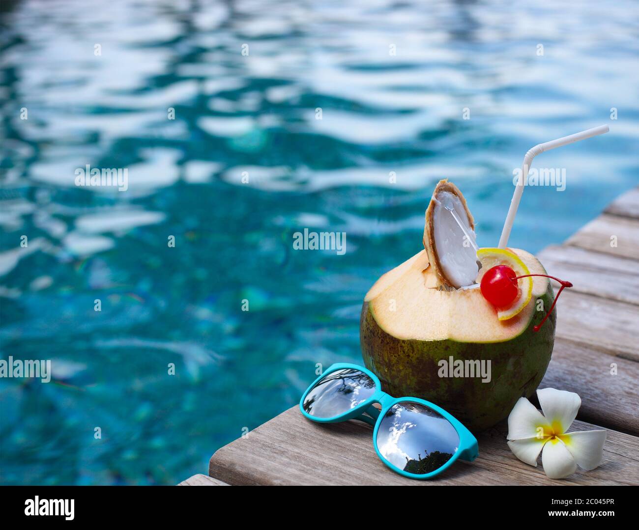 Coconut cocktail with drinking straw by the swimming pool Stock Photo ...