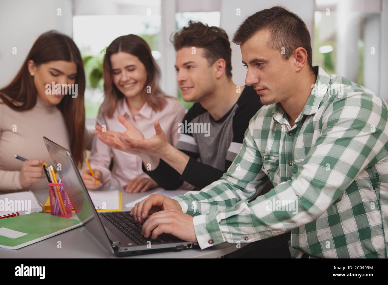 Communication, college concept. Young male student typing on laptop ...