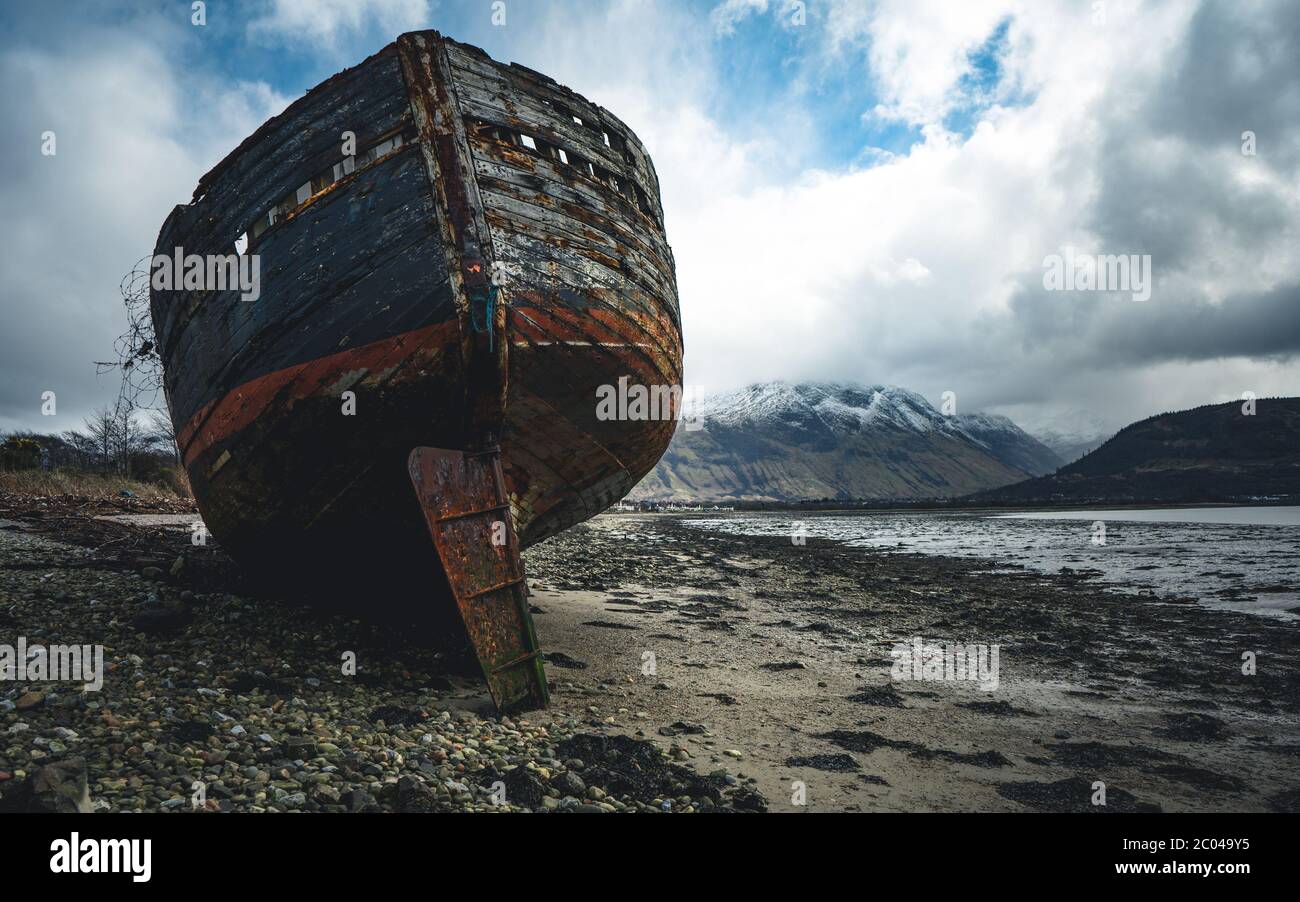 Ship wreck on the beach at low tide. The Old Boat of Corpach, Ben Navis ...