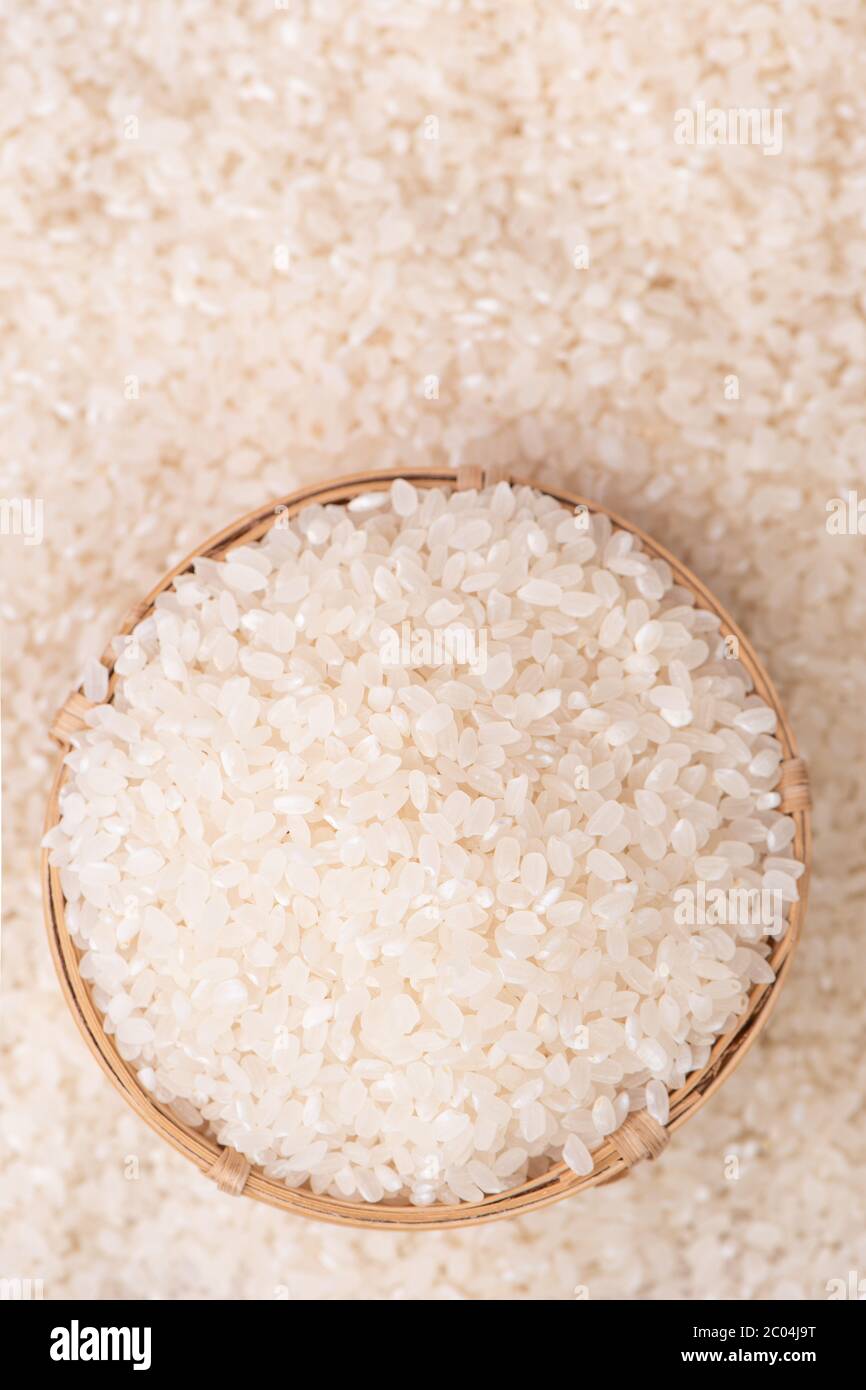 Raw rice in a bowl and full frame in the white background table, top ...