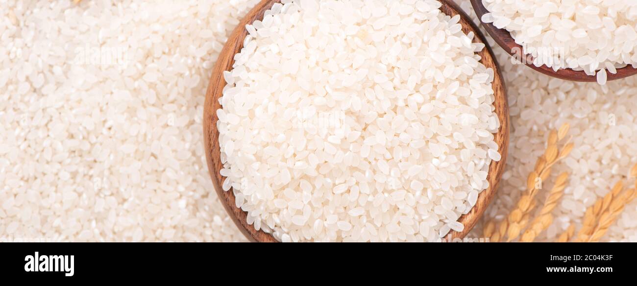 Raw rice in a bowl and full frame in the white background table, top ...