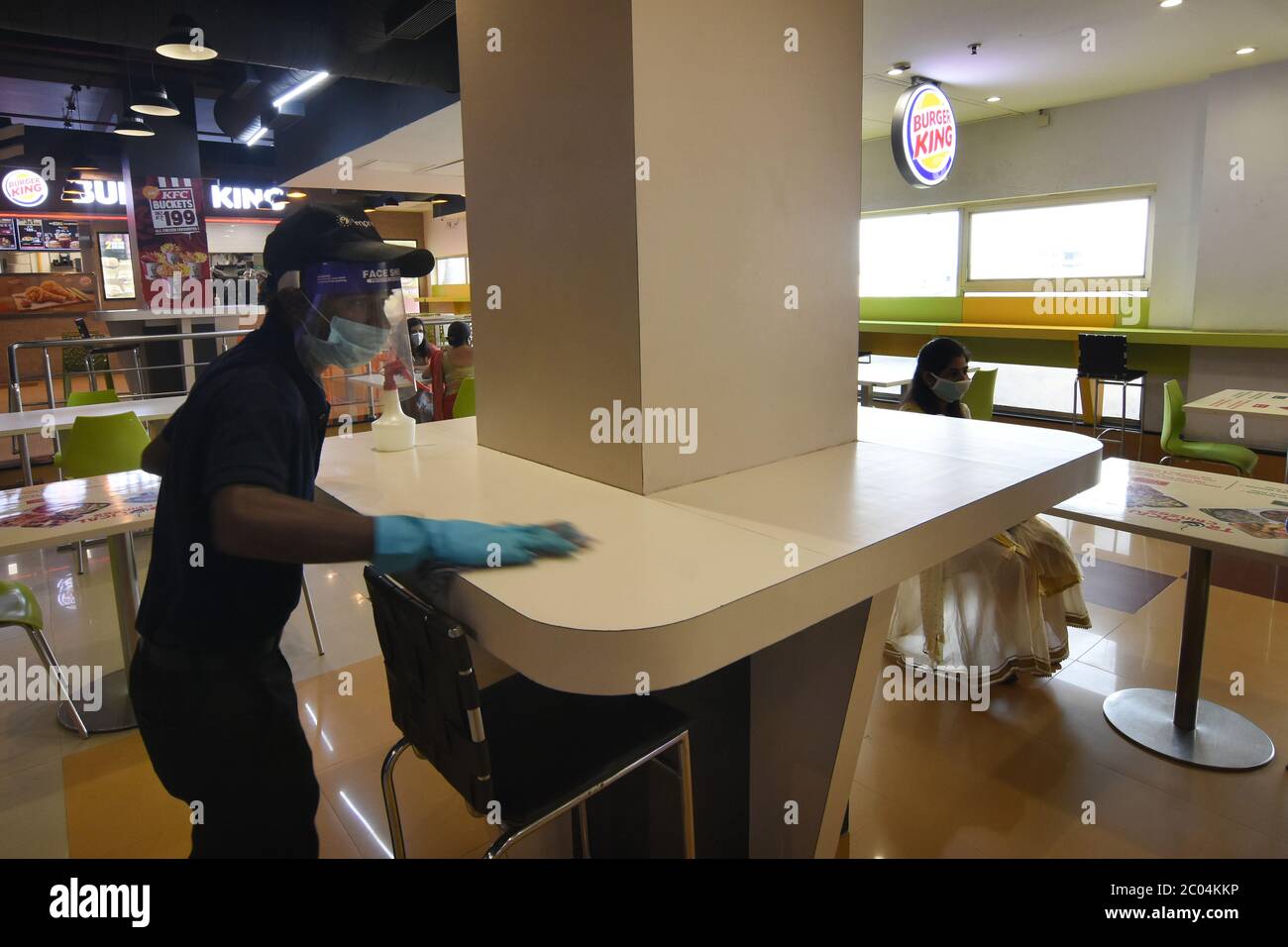 Kolkata, India. 11th June, 2020. A worker cleaning a food court table ...