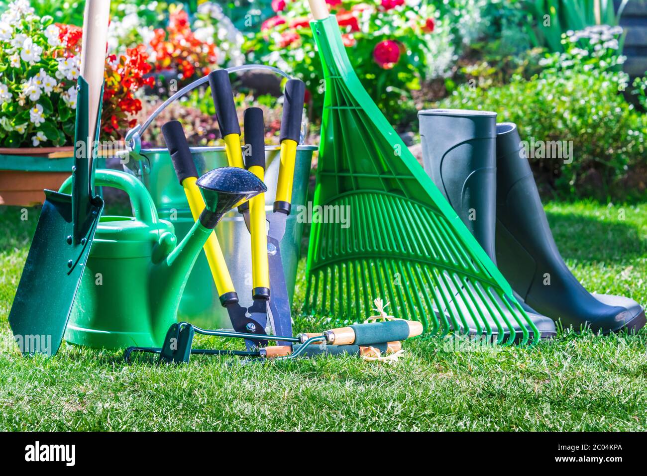Gardening tools on the grass in the garden Stock Photo - Alamy