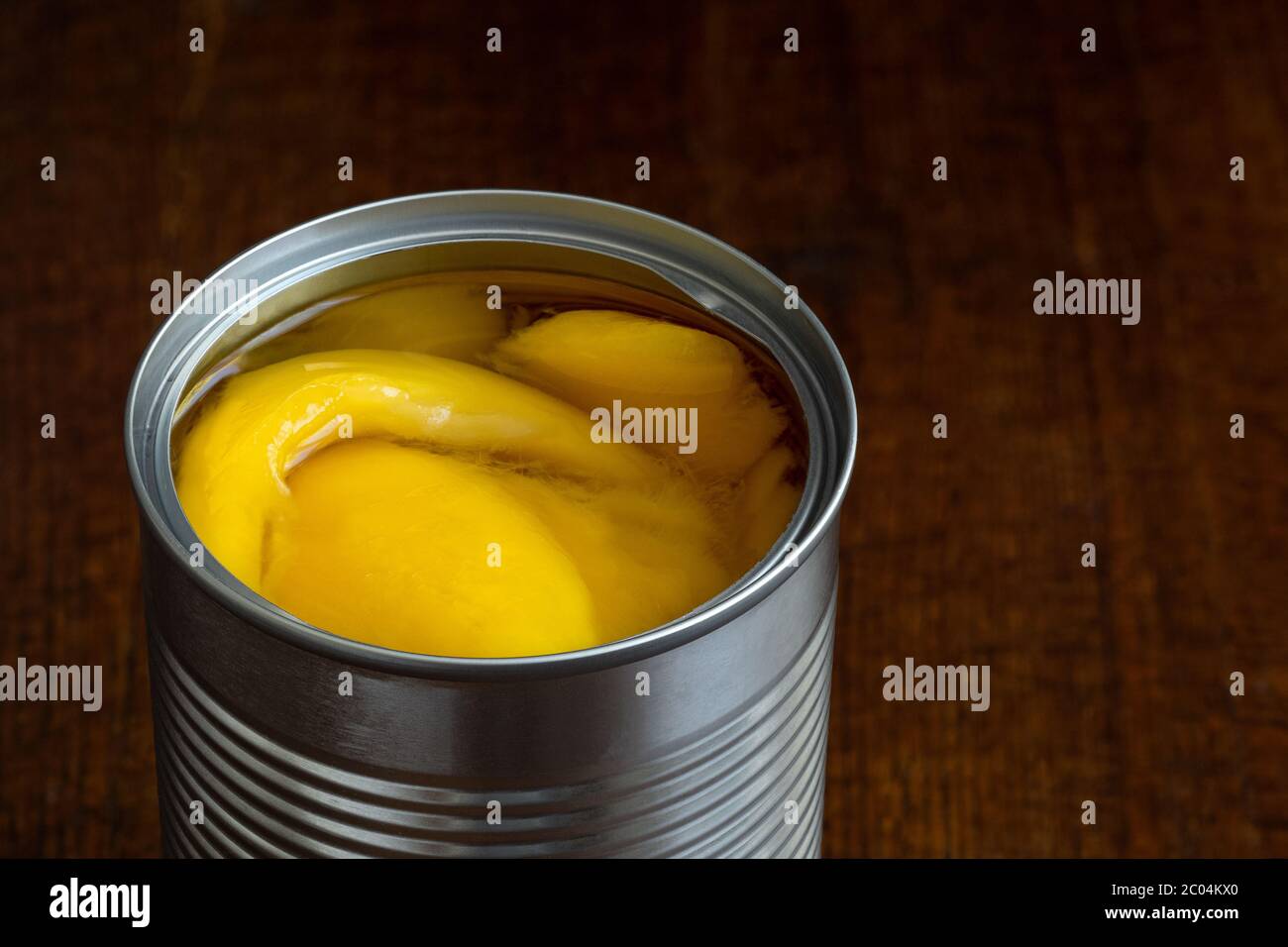 Canned mango slices in syrup in a metal can isolated on white. Dark ...