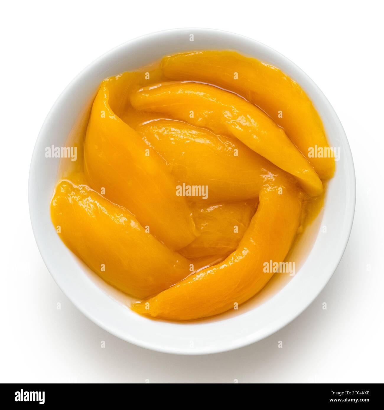 Canned mango slices in syrup in a white ceramic bowl isolated on white ...