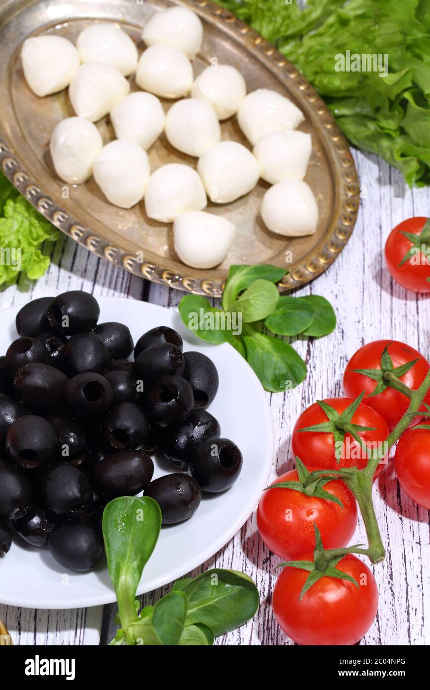 Olives, tomatoes, a mozzarella and ruccola Stock Photo - Alamy