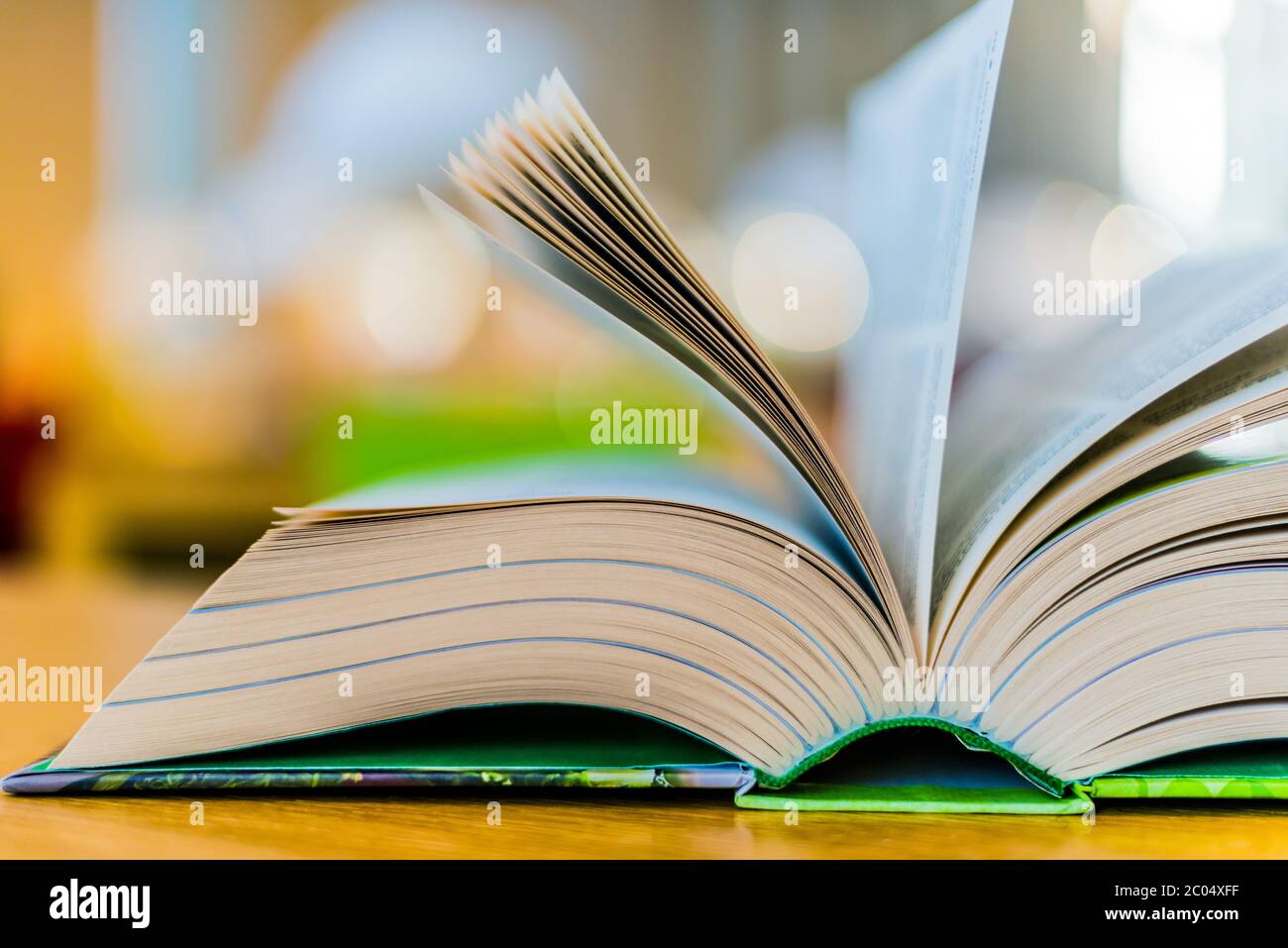 Open book lying on the table in the public library Stock Photo - Alamy