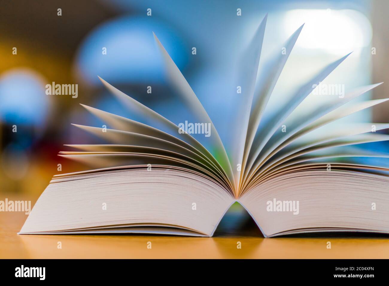Open book lying on the table in the public library Stock Photo - Alamy