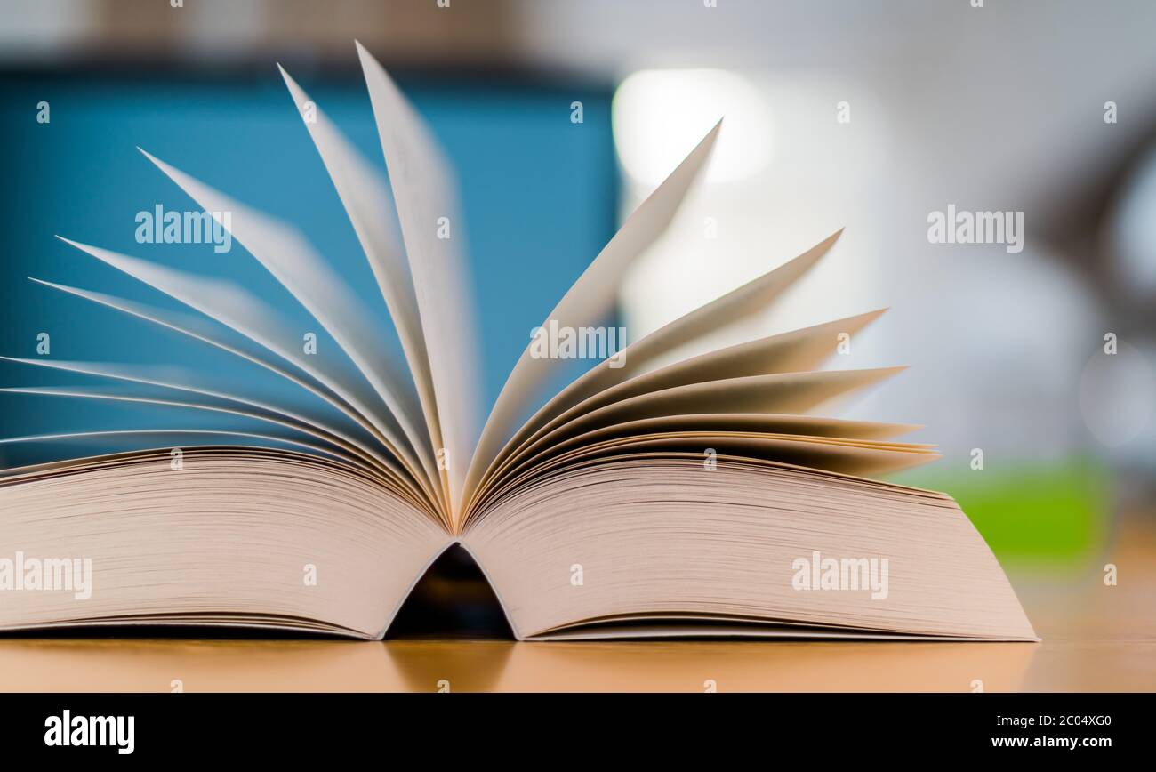 Open book lying on the table in the public library Stock Photo - Alamy