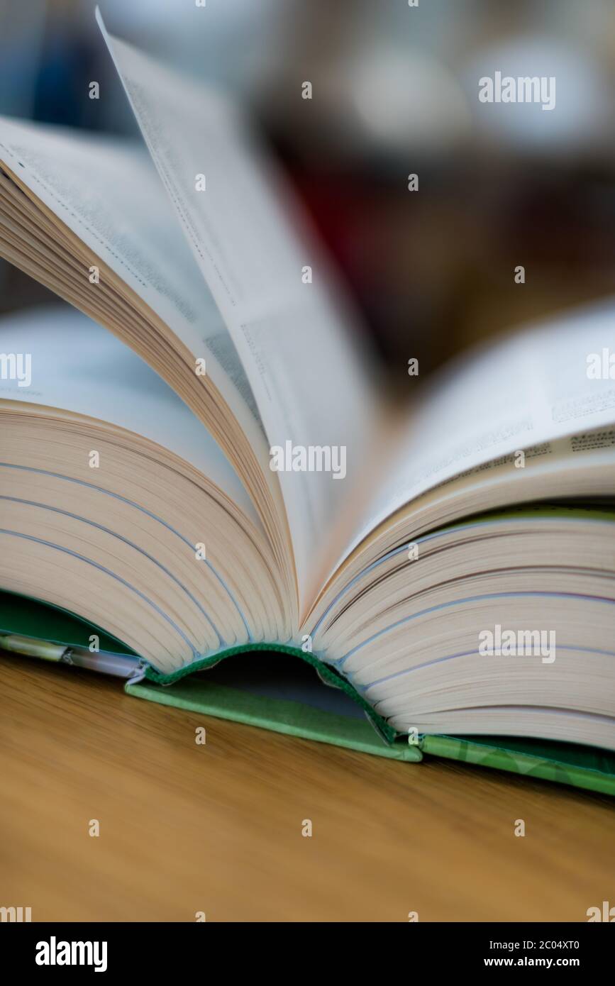 Open book lying on the table in the public library Stock Photo - Alamy