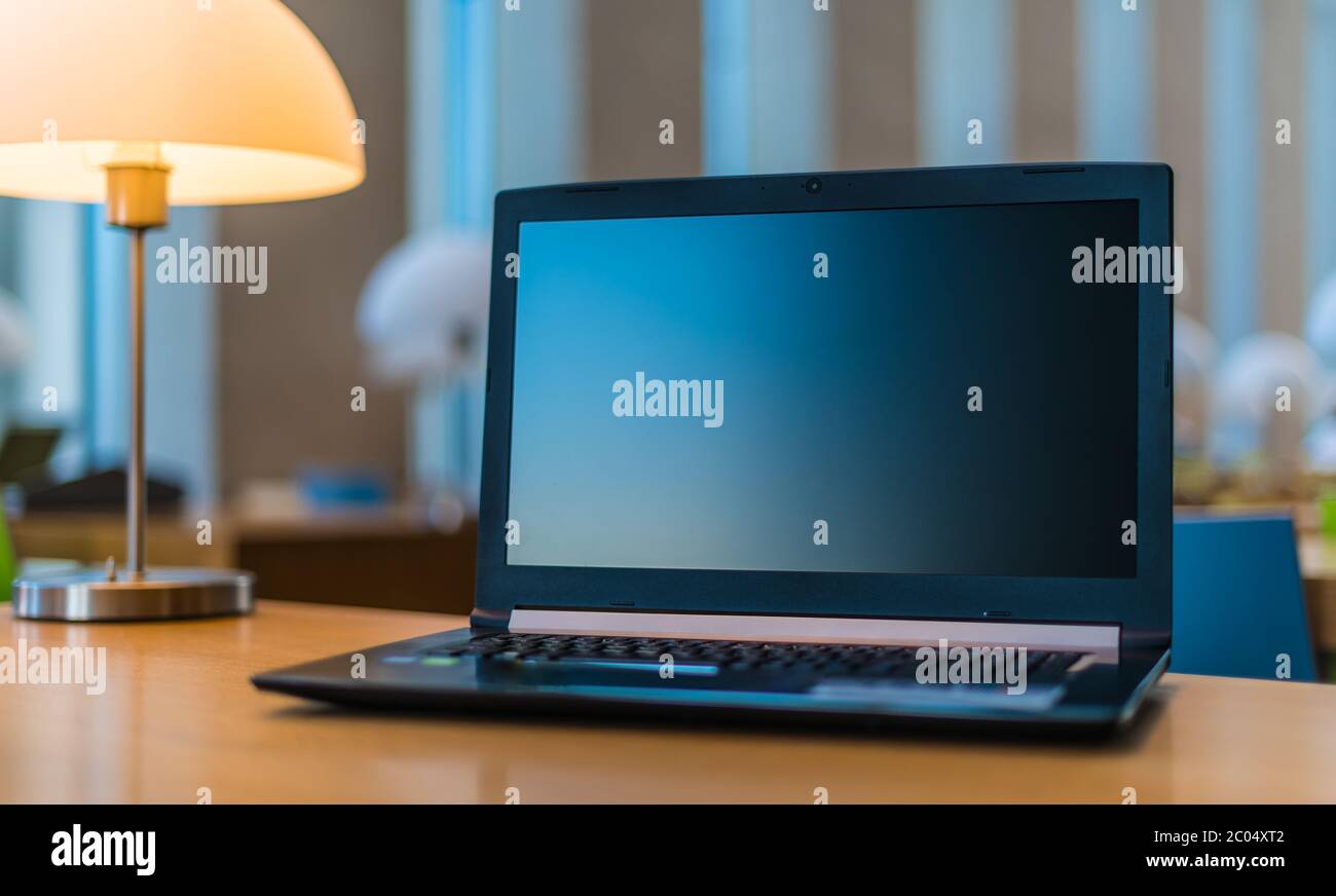 Laptop computer on the desk in public library Stock Photo - Alamy