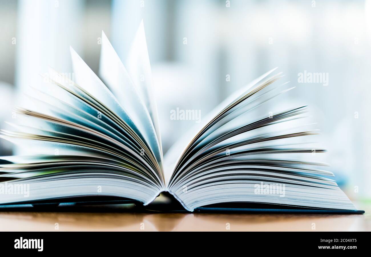 Open book lying on the table in the public library Stock Photo - Alamy