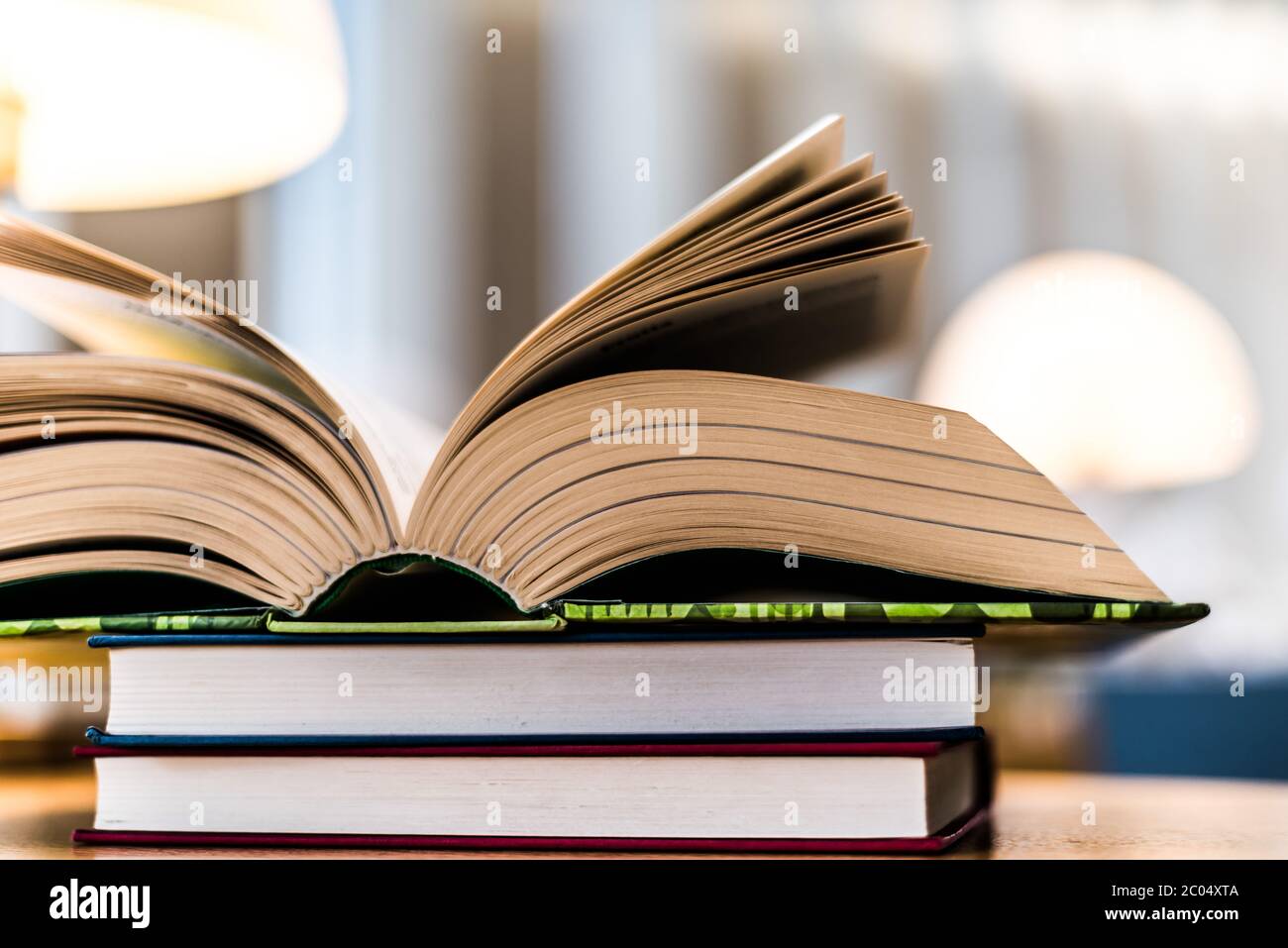 Open book lying on the table in the public library Stock Photo - Alamy