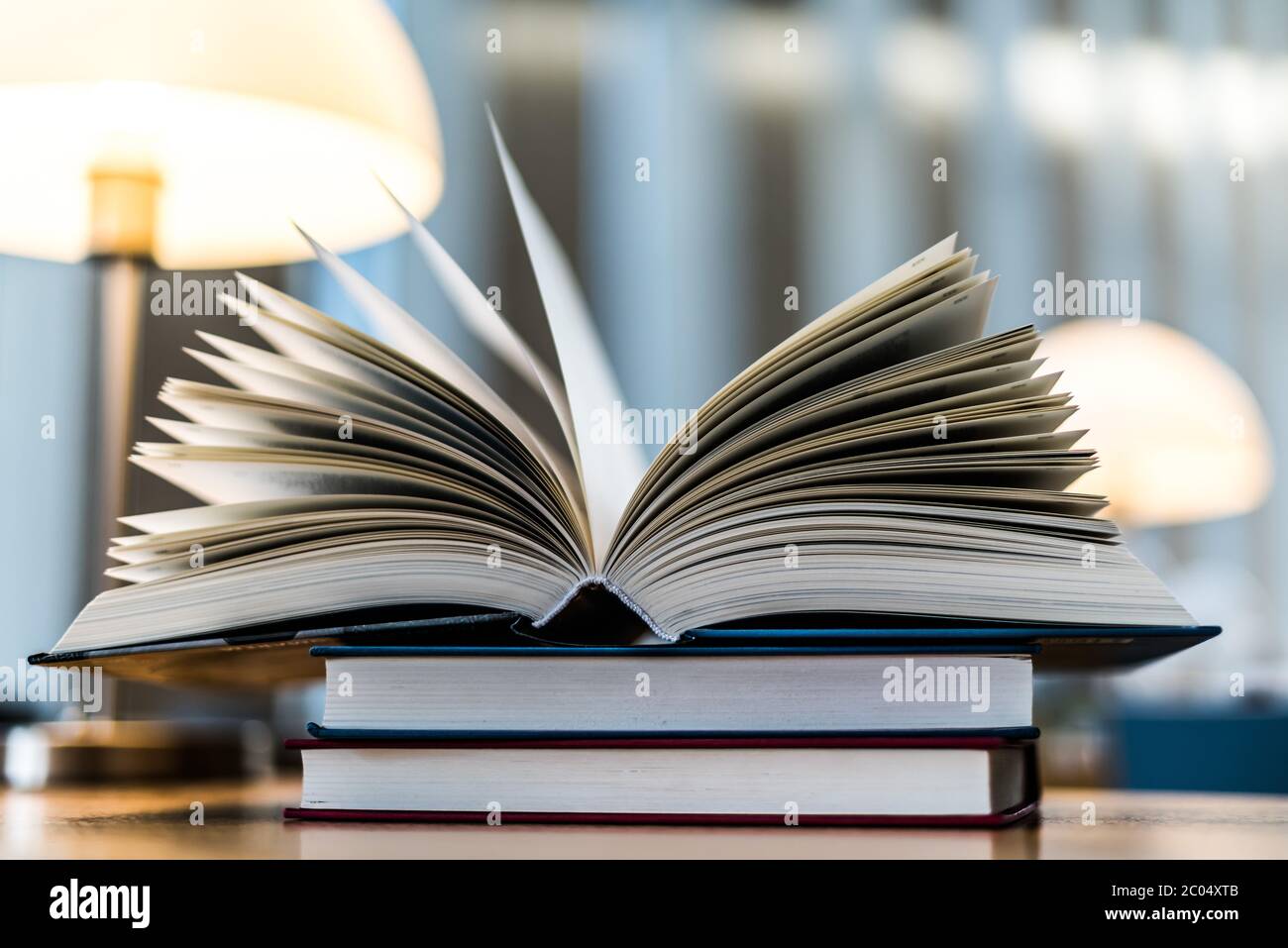 Open book lying on the table in the public library Stock Photo - Alamy