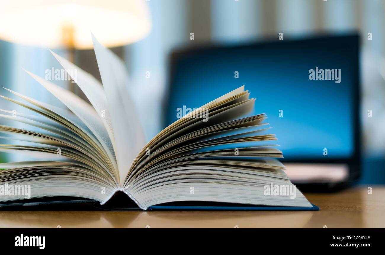 Open book lying on the table in the public library Stock Photo - Alamy