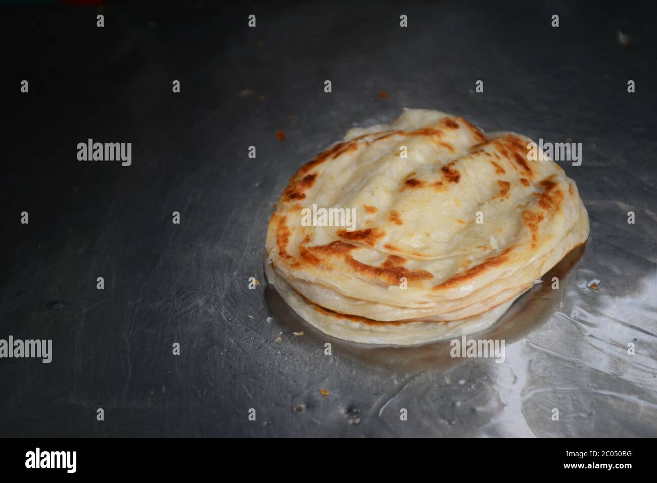 Soft focus of Roti Canai or Roti thresh flour by roti maker with oil ...