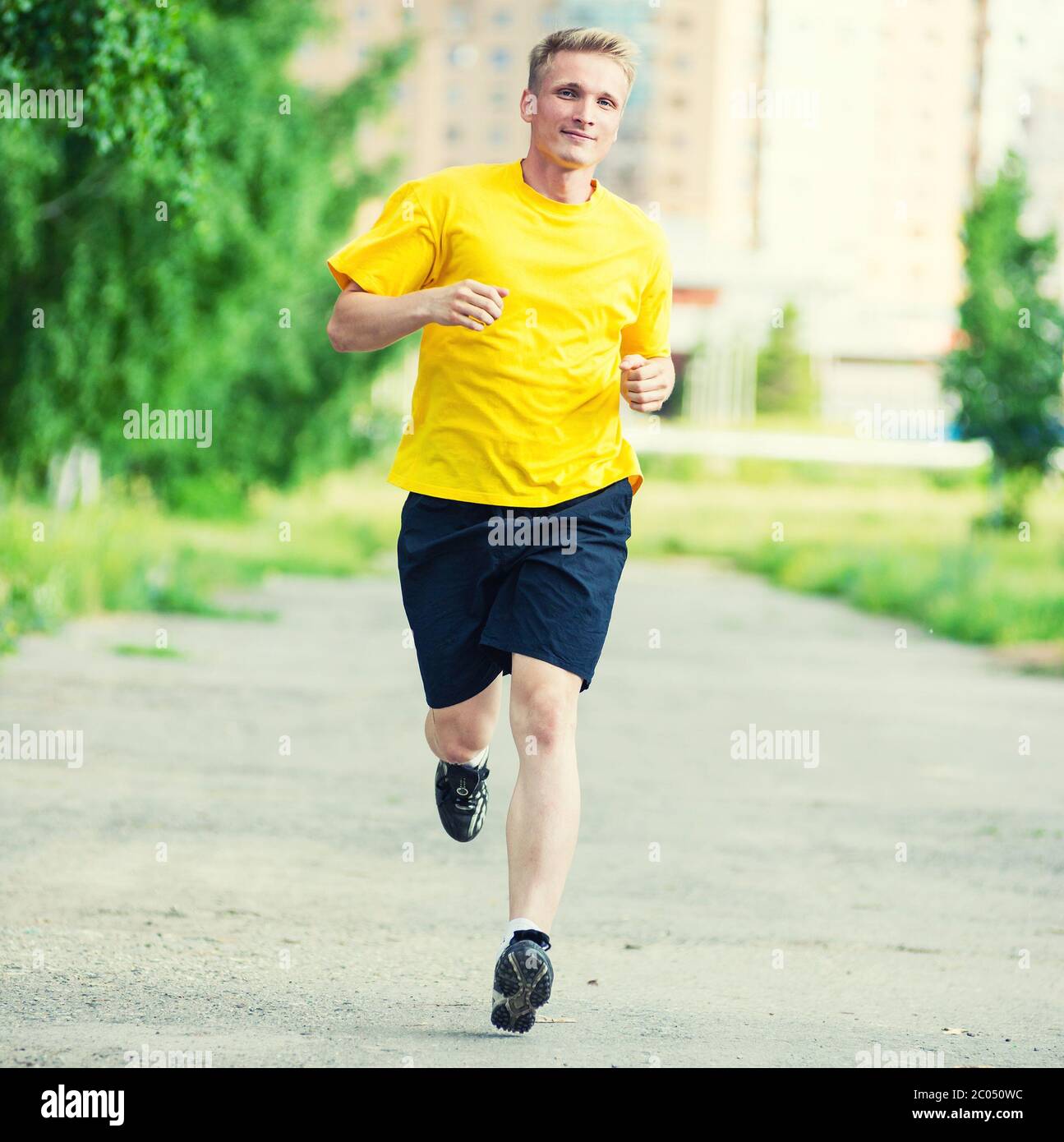 Sporty man jogging in city street park. Outdoor fitness Stock Photo - Alamy