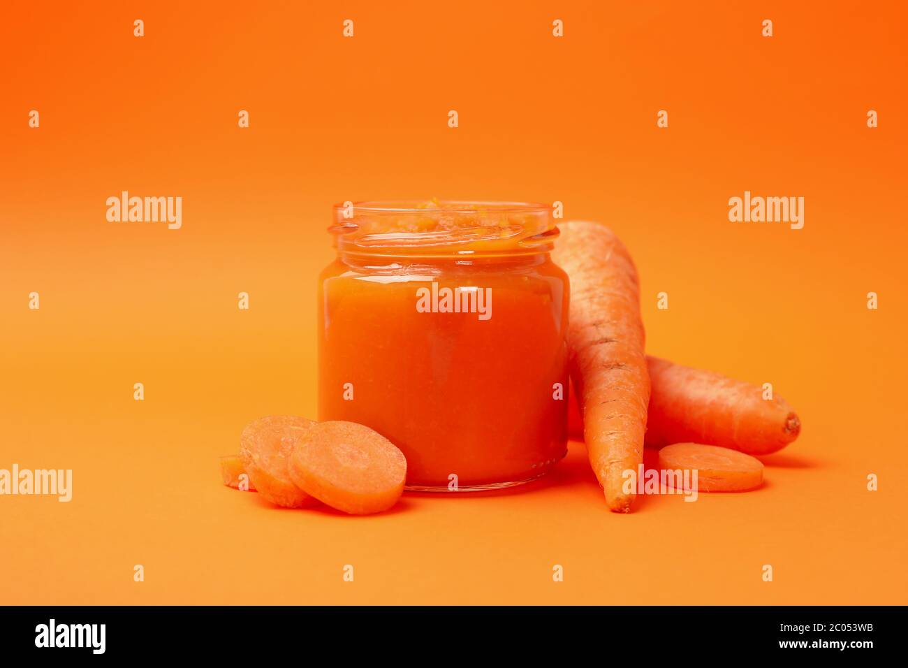 Composition with vegetable puree on orange background. Baby food Stock ...
