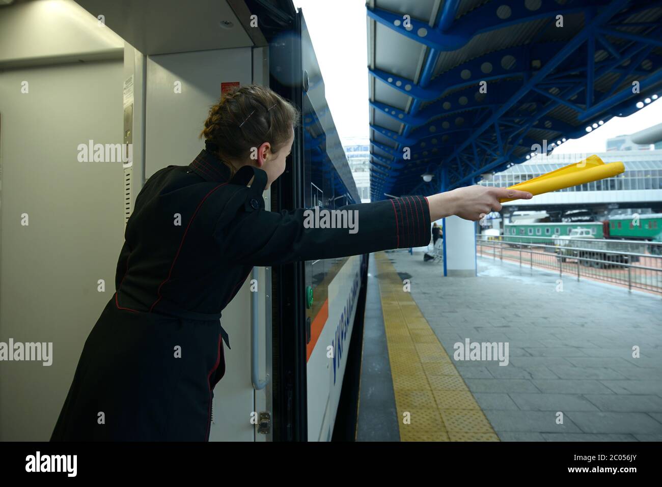 Female train conductor signaling departure of the passenger train ...