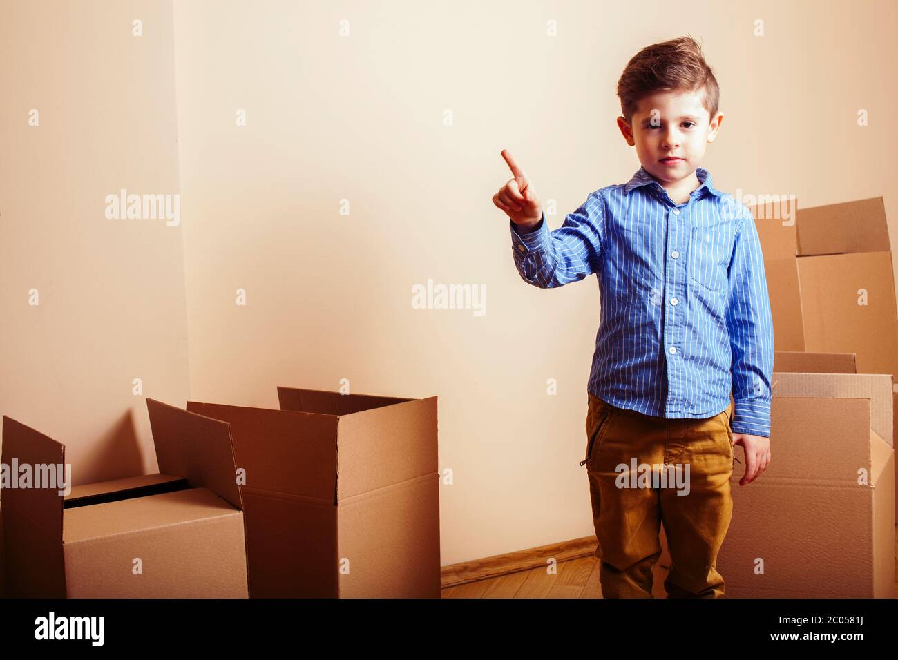 little cute boy in empty room, move to new house. home alone among ...