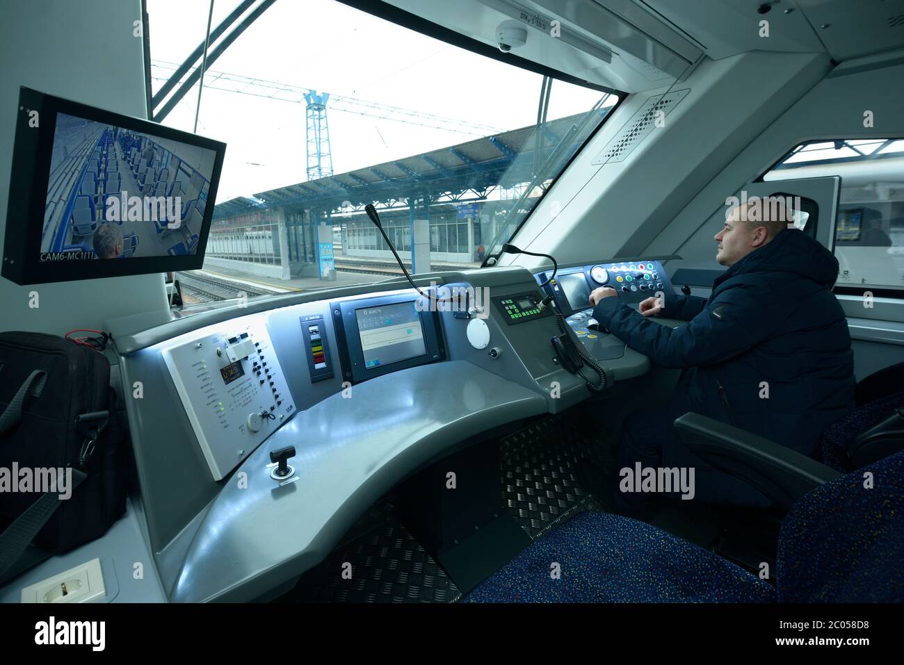 At the cabin of the passenger train. Train driver sitting in front of ...