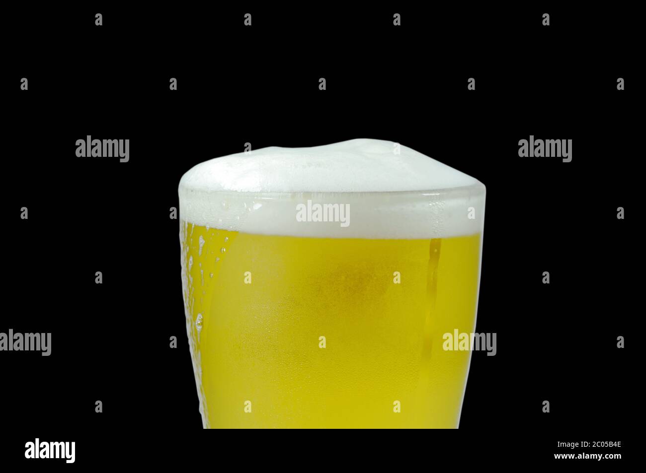 cold beer with frothy in glass on black background Stock Photo - Alamy