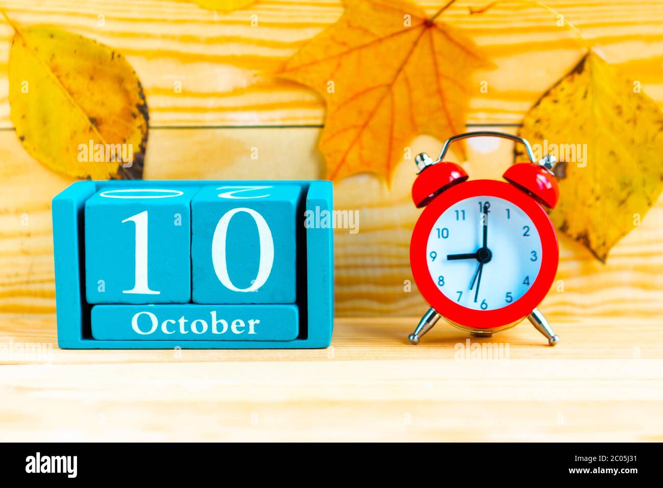 October the 10th. Blue cube calendar with month and date and alarm ...