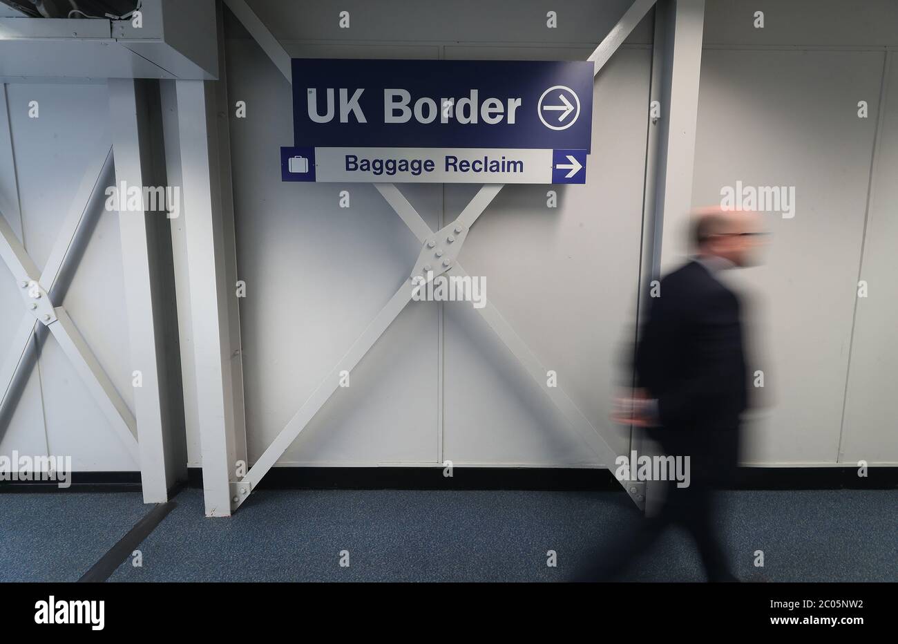 A man passes a UK border sign at Belfast International Airport which ...