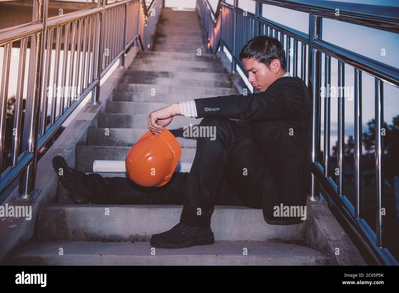 Engineers frustrated frustrated sitting on the overpass Stock Photo - Alamy