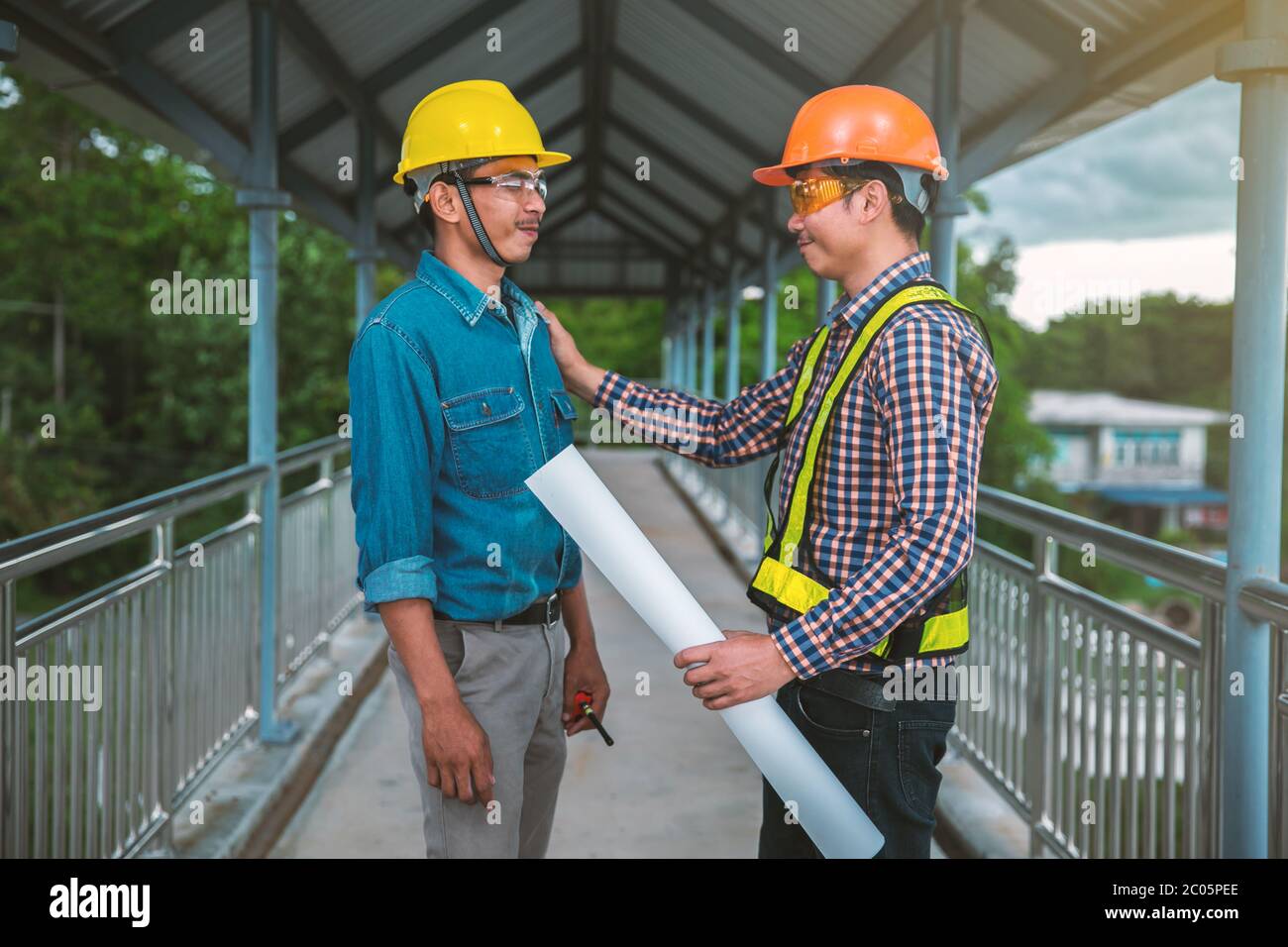 Two engineers stand hand in hand on bridge Stock Photo - Alamy
