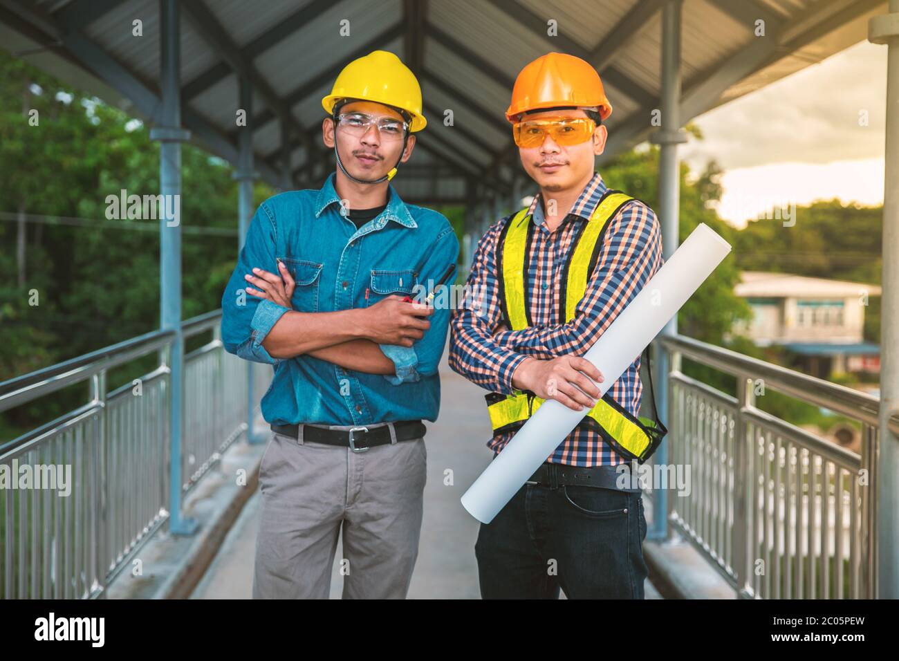 Two engineers stand hand in hand on bridge Stock Photo - Alamy