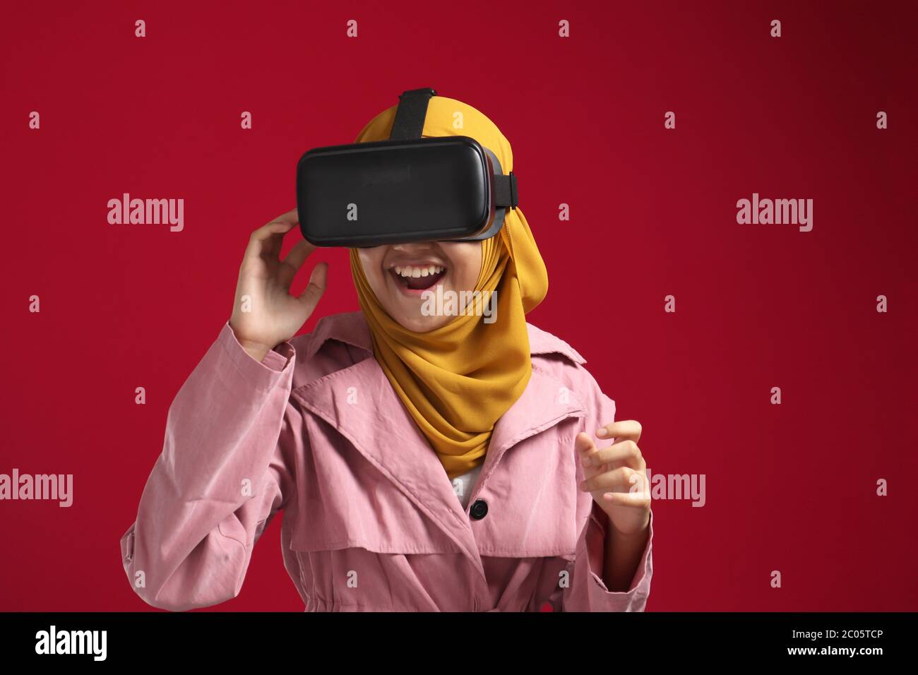 Happy young Asian muslim girl wearing hijab playing on VR glasses ...