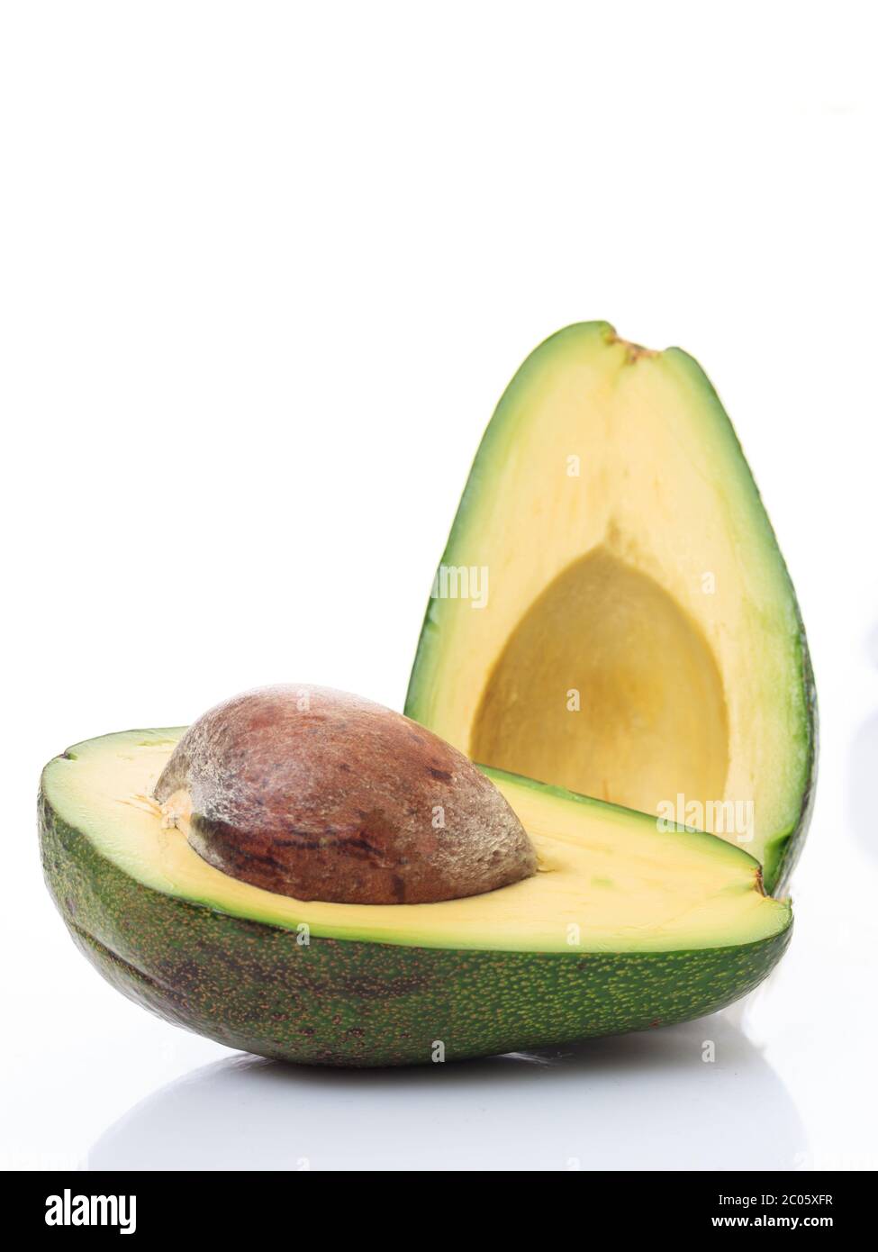 Healthy lifestyle concept. Avocado cut in two isolated on white ...