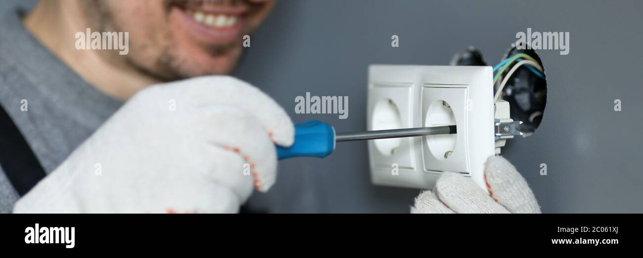 Handyman using screwdriver to install sockets Stock Photo - Alamy