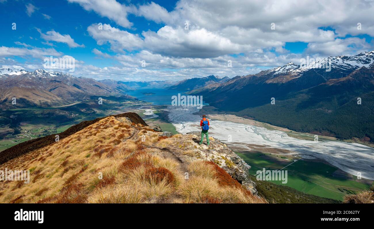 Hiker on the summit of Mount Alfred, views of Lake Wakatipu and ...