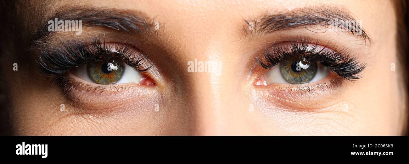 Pair of beautiful female green colored eyes with eyelashes extensions ...