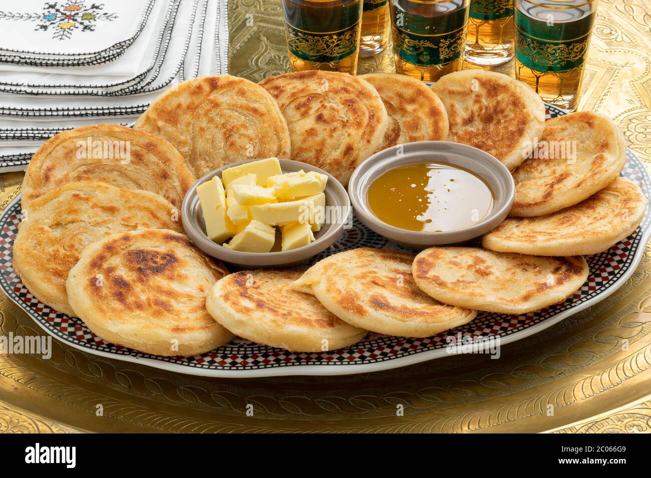 Fresh baked meloui, Moroccan pancakes with butter and honey on a plate ...