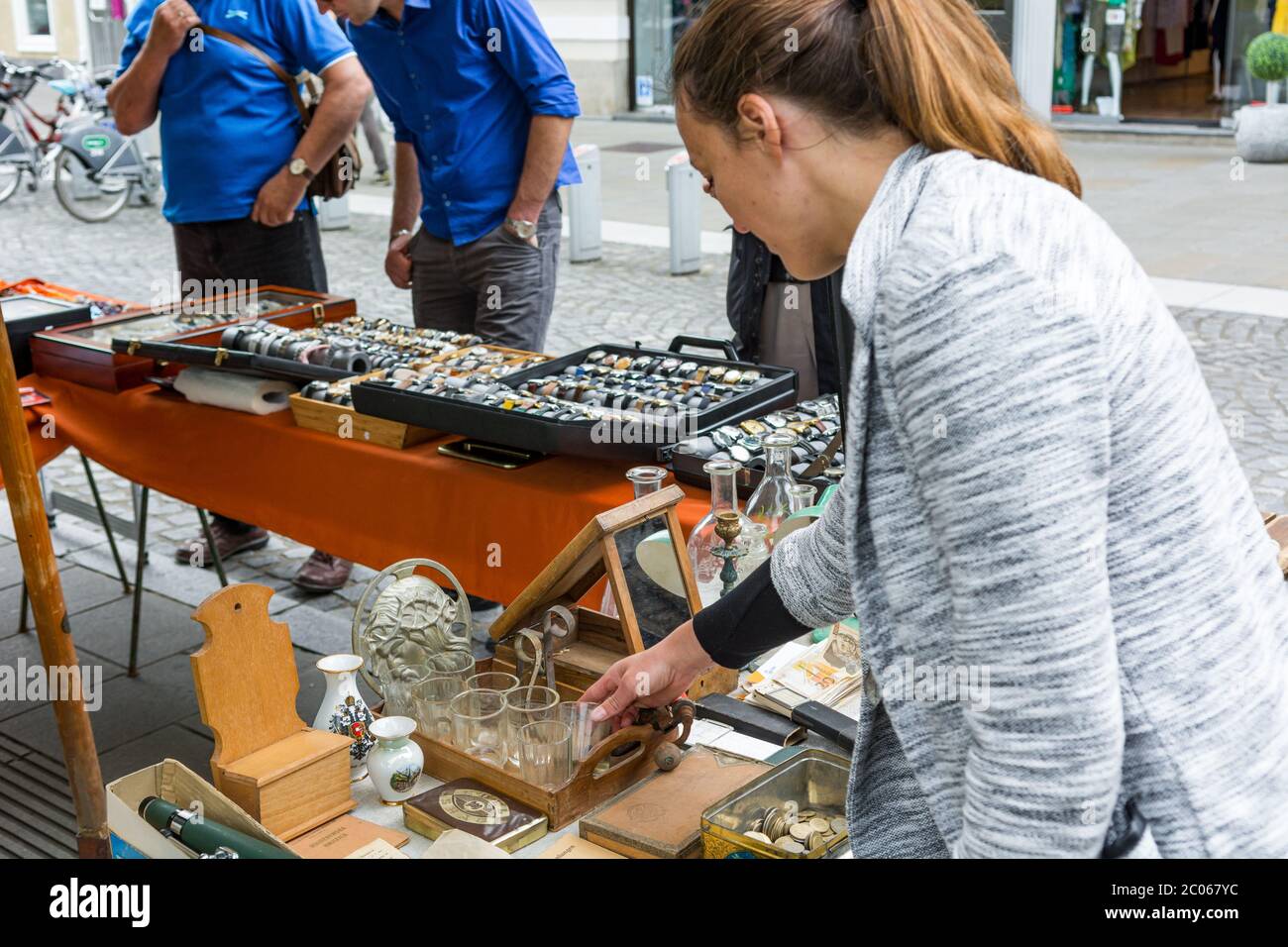Female customer checking items sold at flee market Stock Photo - Alamy