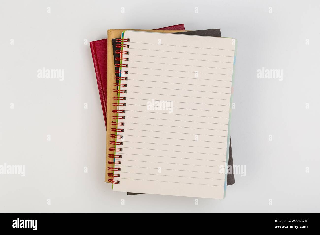 a stack of several spiral school notebooks lies on a white table with a ...
