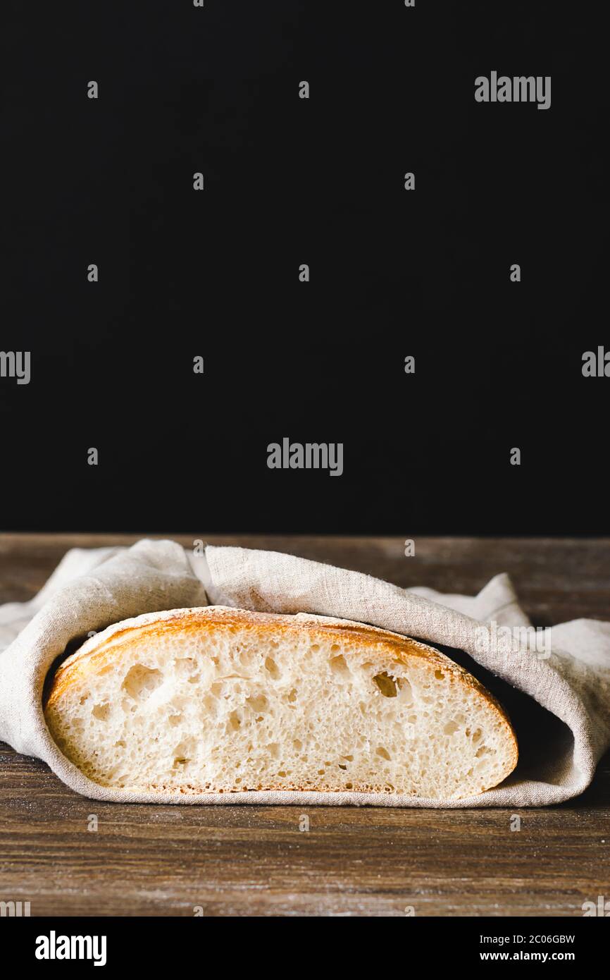 Fresh baked white bread slice slice on a dark background. Front view ...