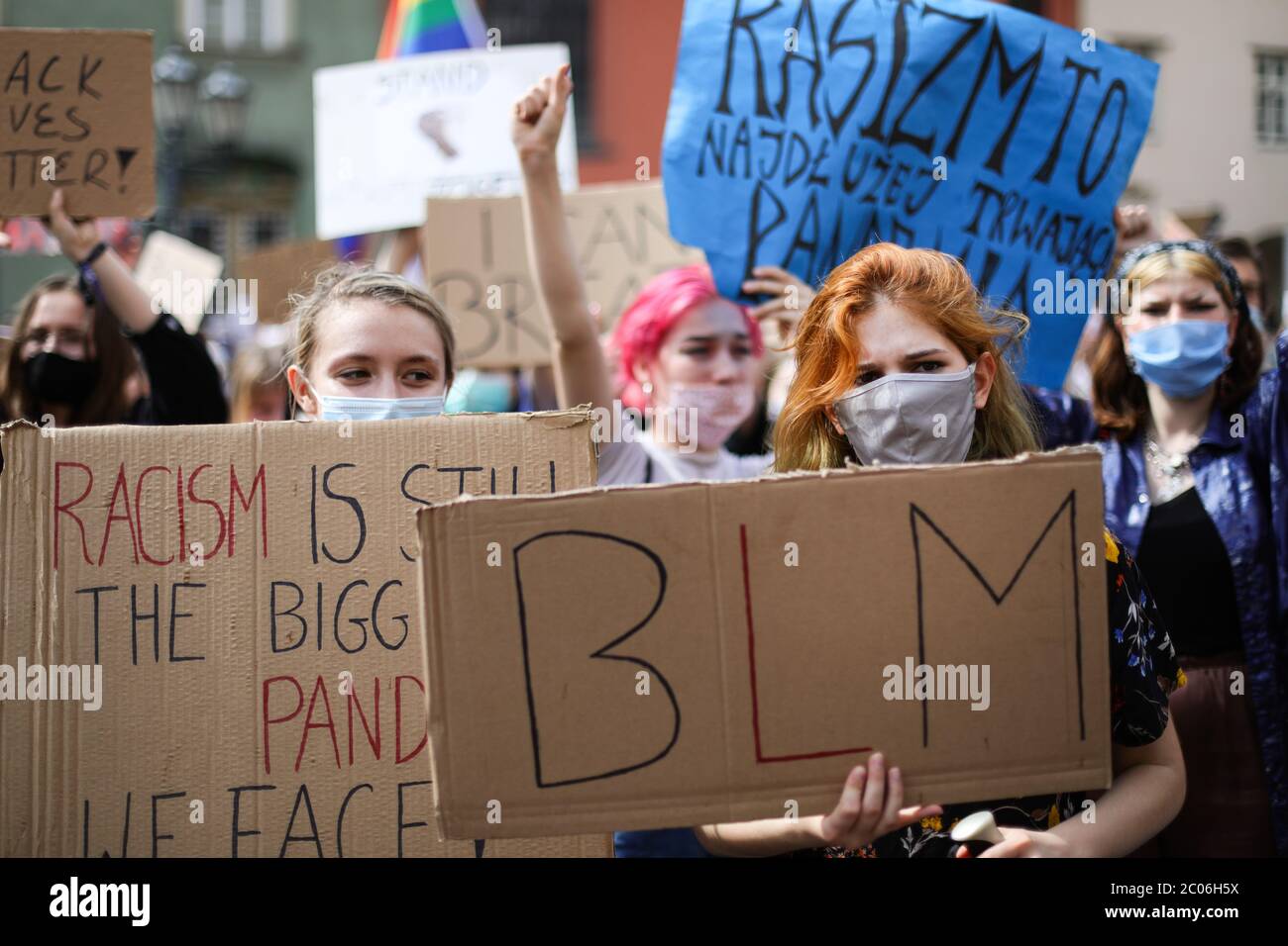 Protesters in a medical masks hold placards with slogans condemning ...