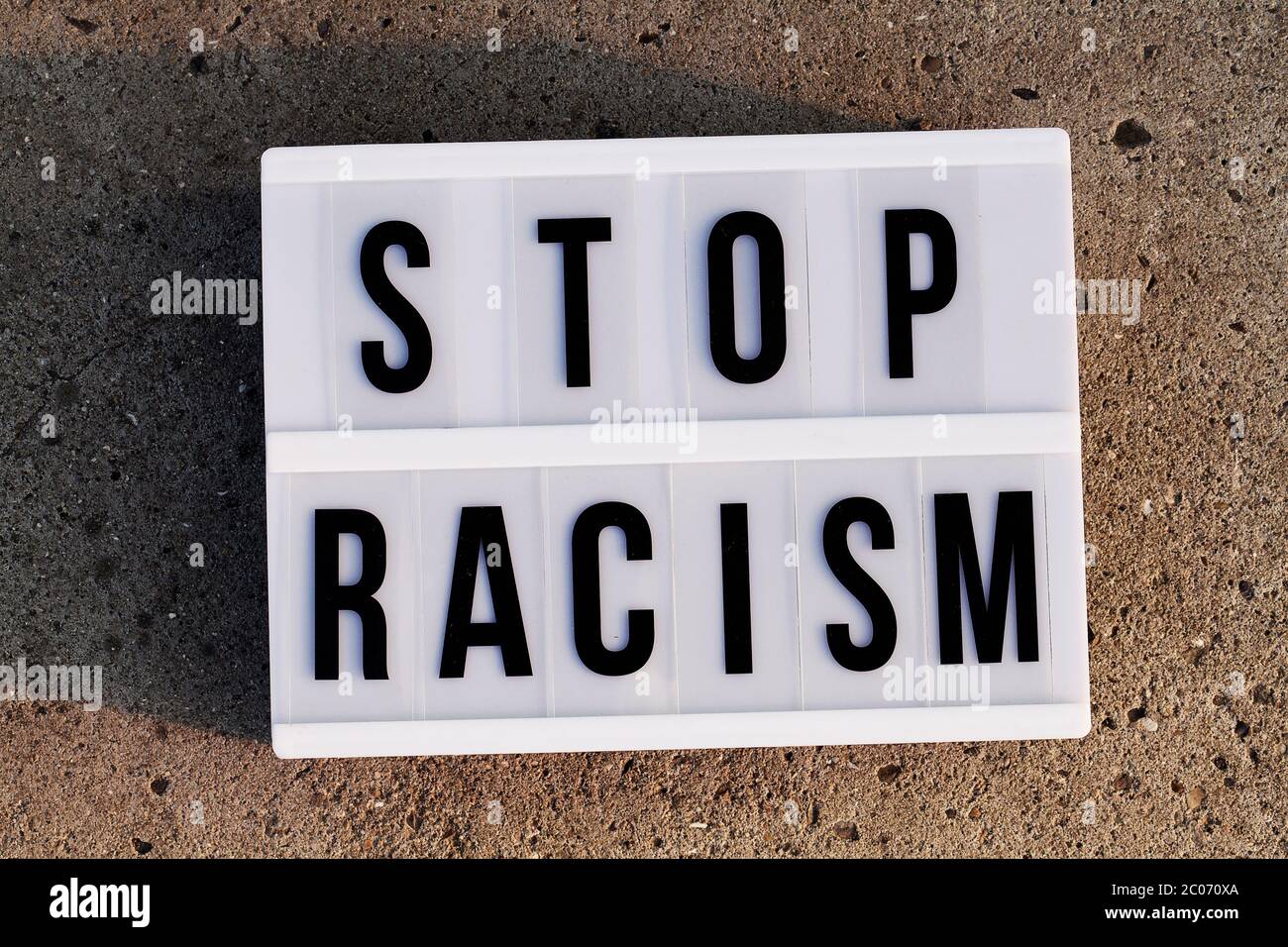 light box with text STOP Racism on gray background top view flat lay ...