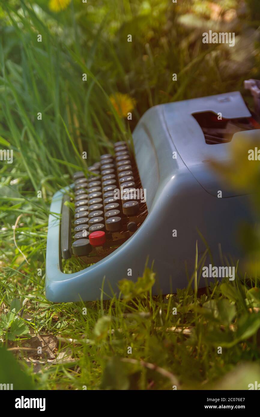 Old blue vintage typewriter on the green grass Stock Photo - Alamy