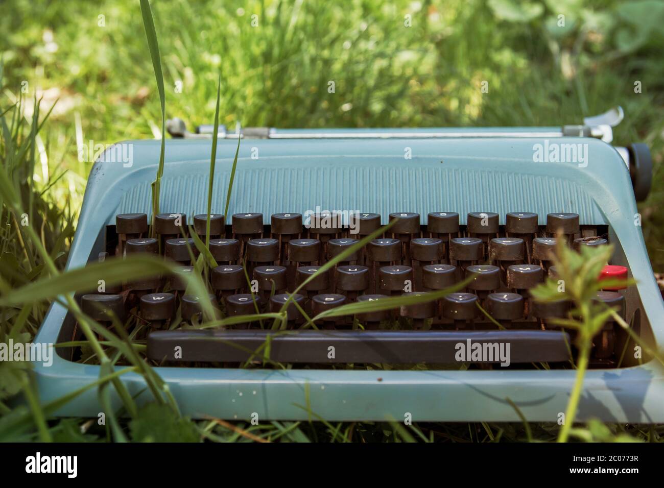 Old blue vintage typewriter on the green grass Stock Photo - Alamy