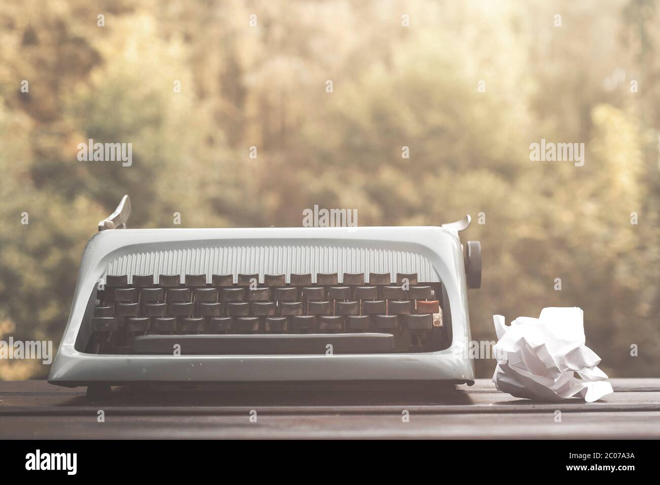Old typewriter and crumpled paper in the garden table Stock Photo - Alamy