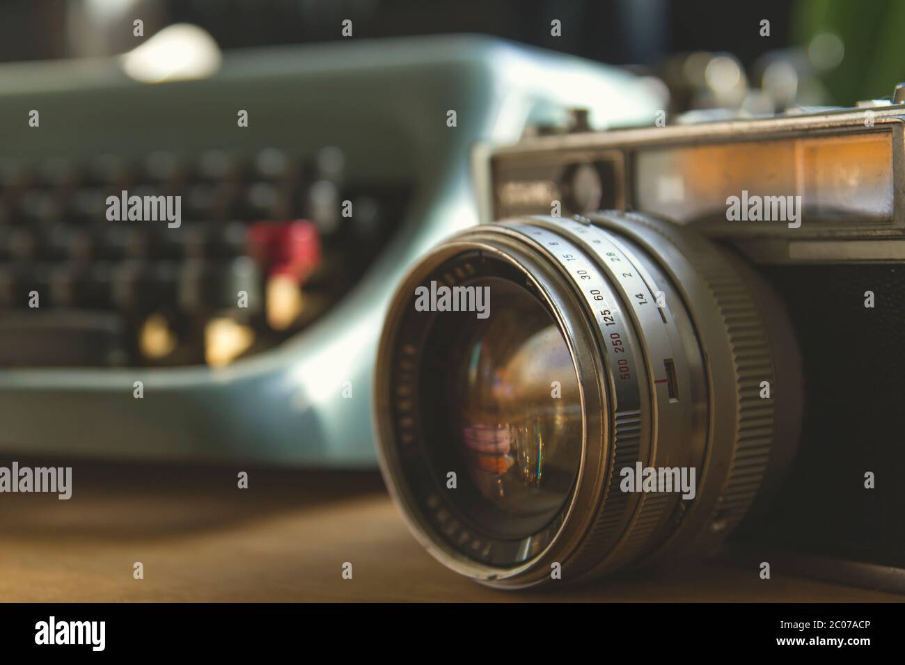 Old photo camera and blue vintage typewriter on a desk Stock Photo - Alamy