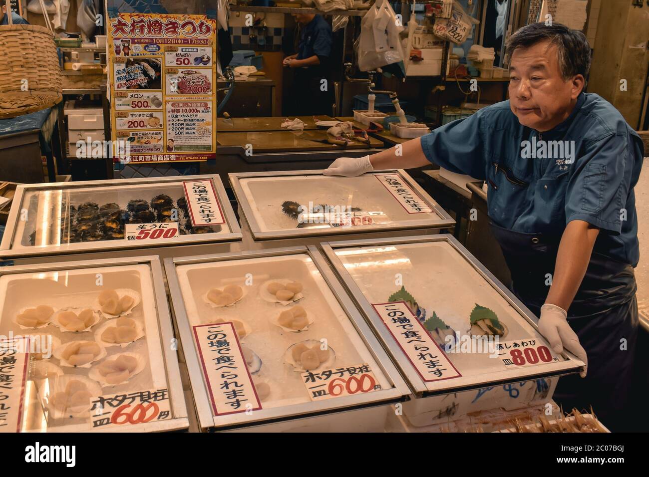 Japanese salesman selling seafood at fish market in Kanazawa Japan ...