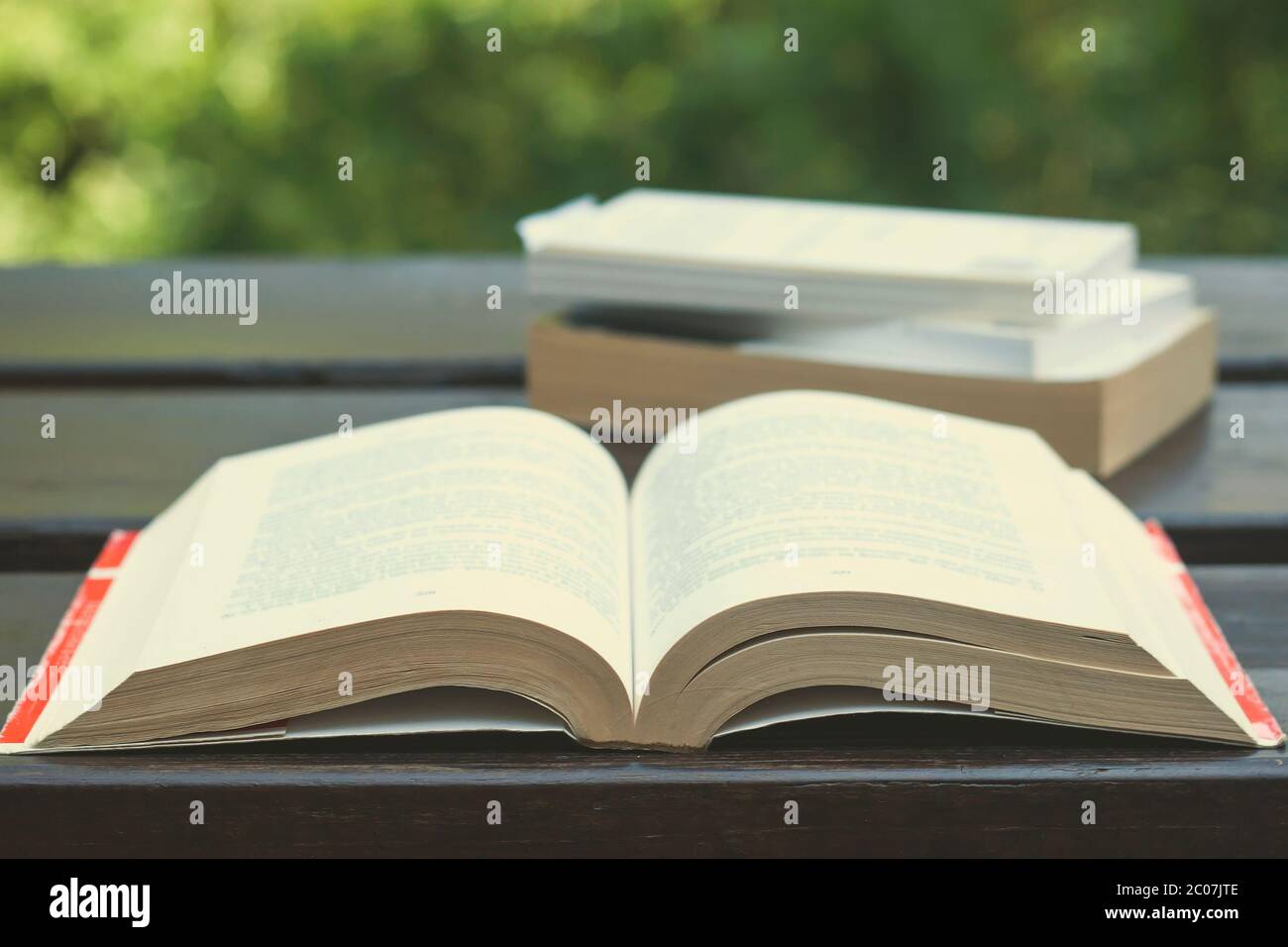 Open book on the garden wooden table Stock Photo - Alamy
