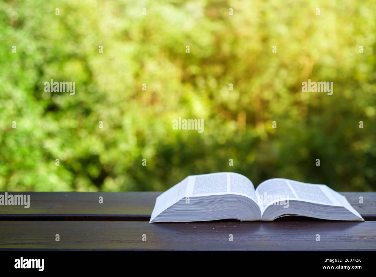 Open book on the garden wooden table Stock Photo - Alamy