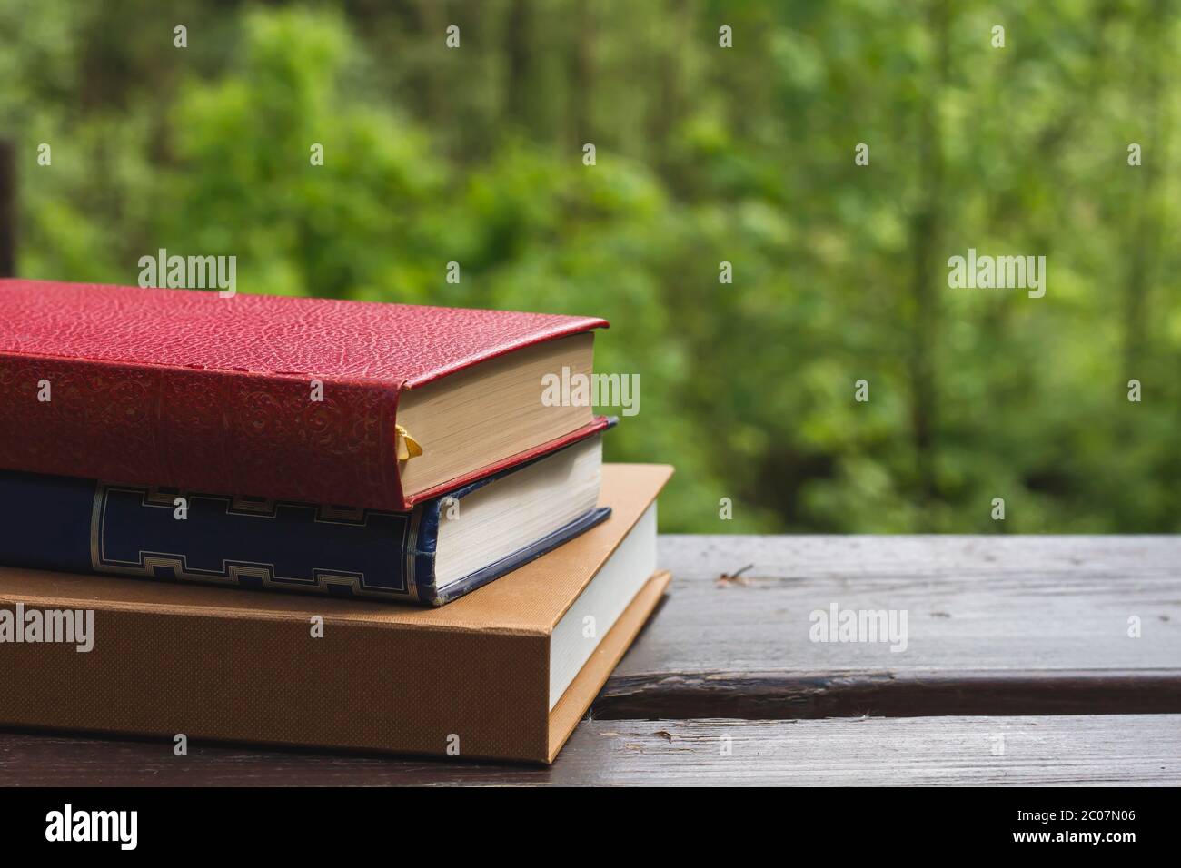 Pile of old books in the garden wooden table Stock Photo - Alamy